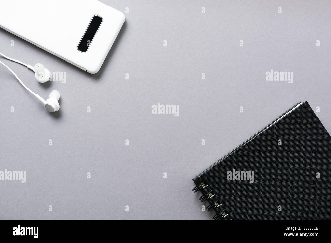 Modern White headphones, a notepad for notes and a mobile phone on a ...