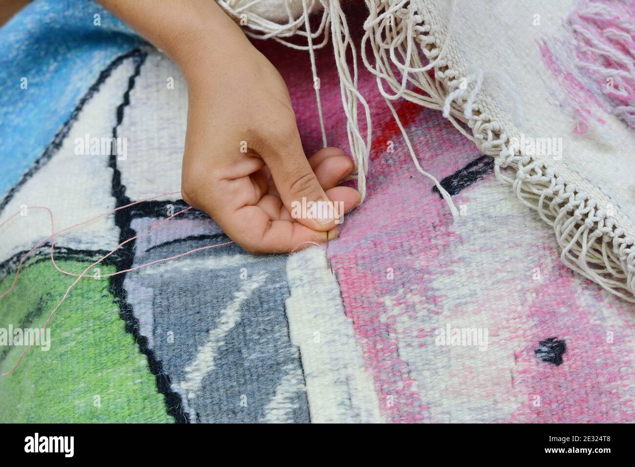 weaving and manufacturing of handmade carpets closeup. women's hands ...