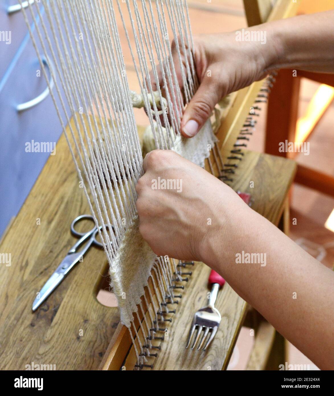 weaving and manufacturing of handmade carpets closeup. women's hands ...
