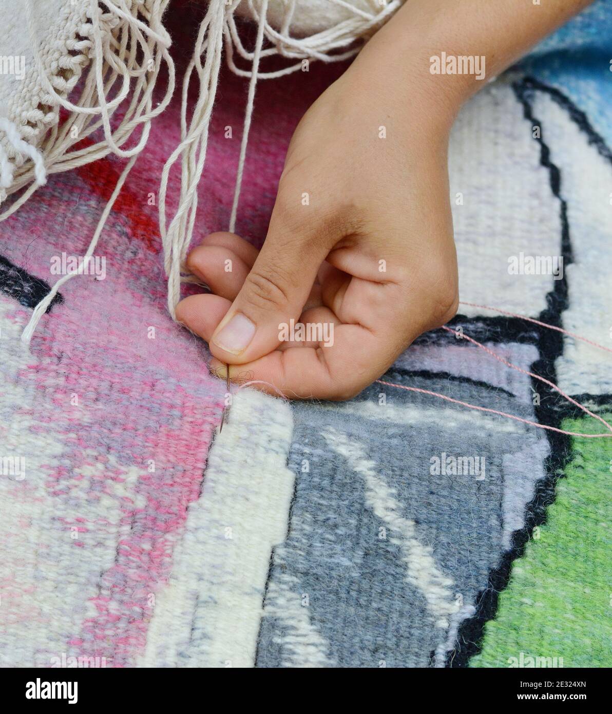 weaving and manufacturing of handmade carpets closeup. women's hands ...