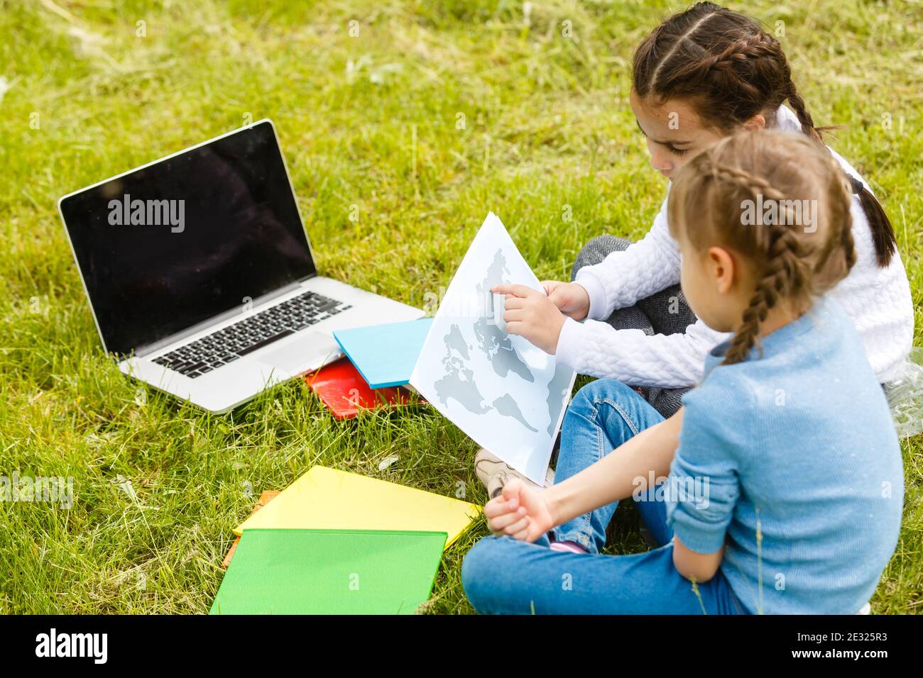 Two beautiful sisters do their homework during quarantine. Children use ...