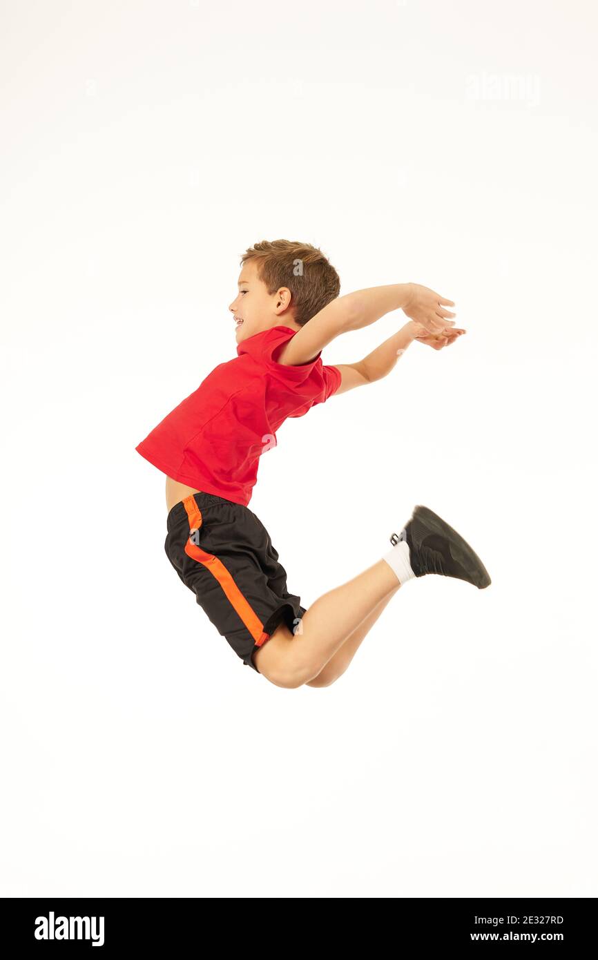 Adorable male child in sportswear looking away and smiling while ...