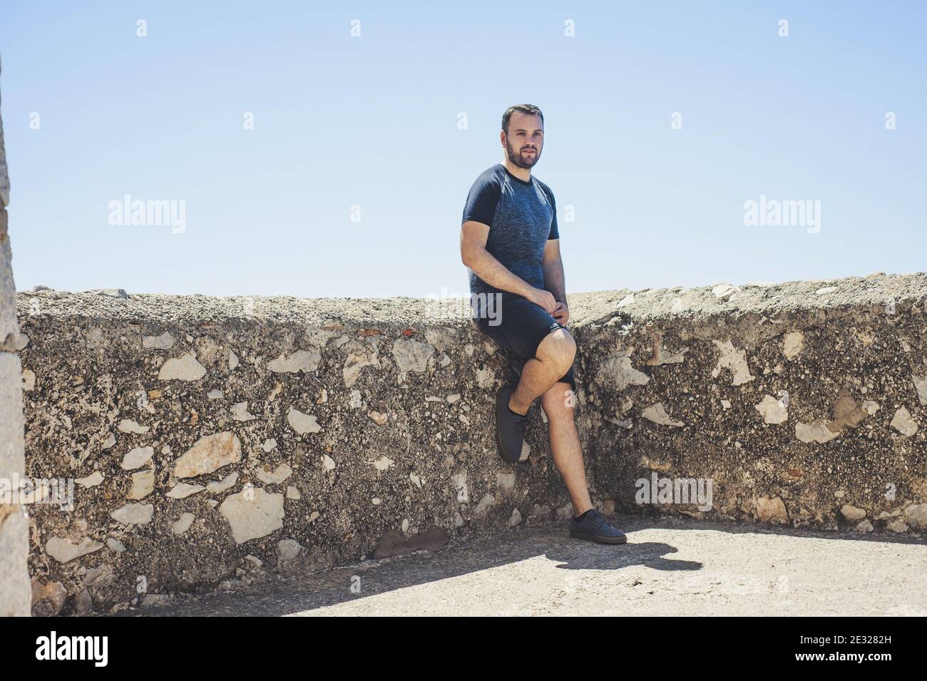 Low angle shot of man standing near the stone wall Stock Photo - Alamy