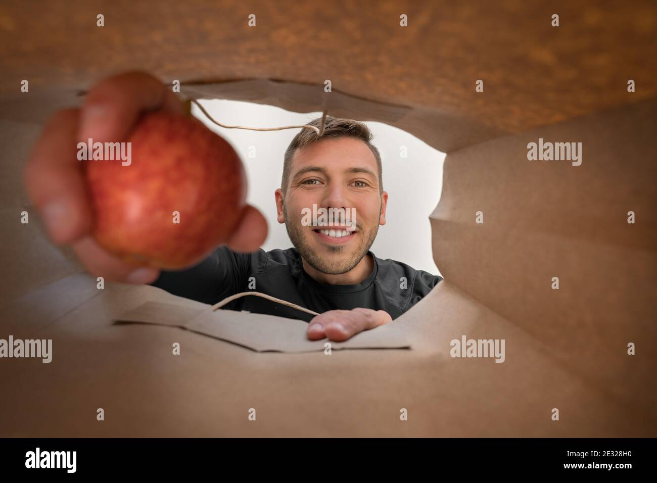 happy-man-taking-food-out-of-paper-bag-home-delivery-from-grocery-shop