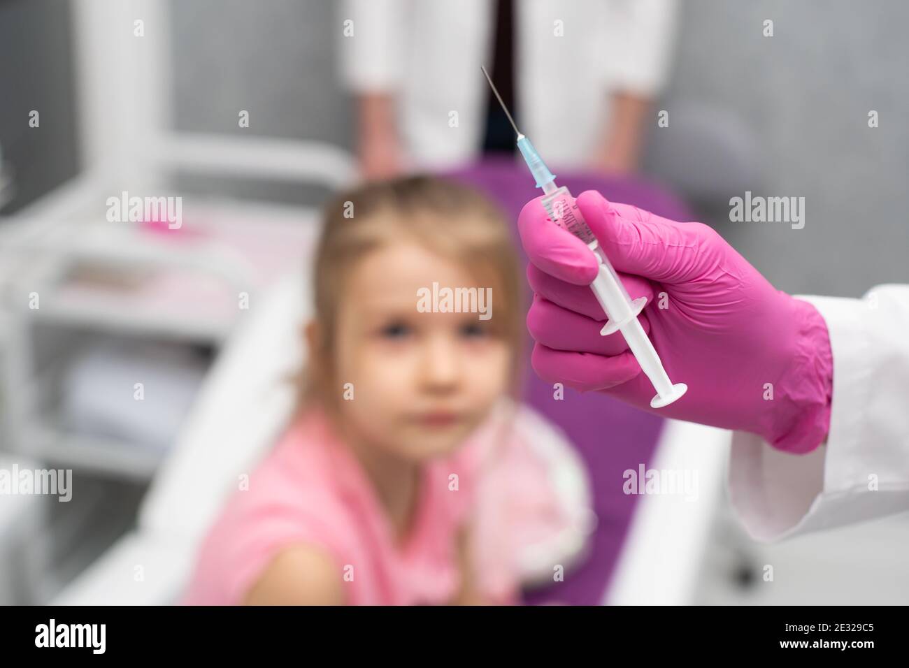 The child watches as the doctor prepares the needle and syringe for ...