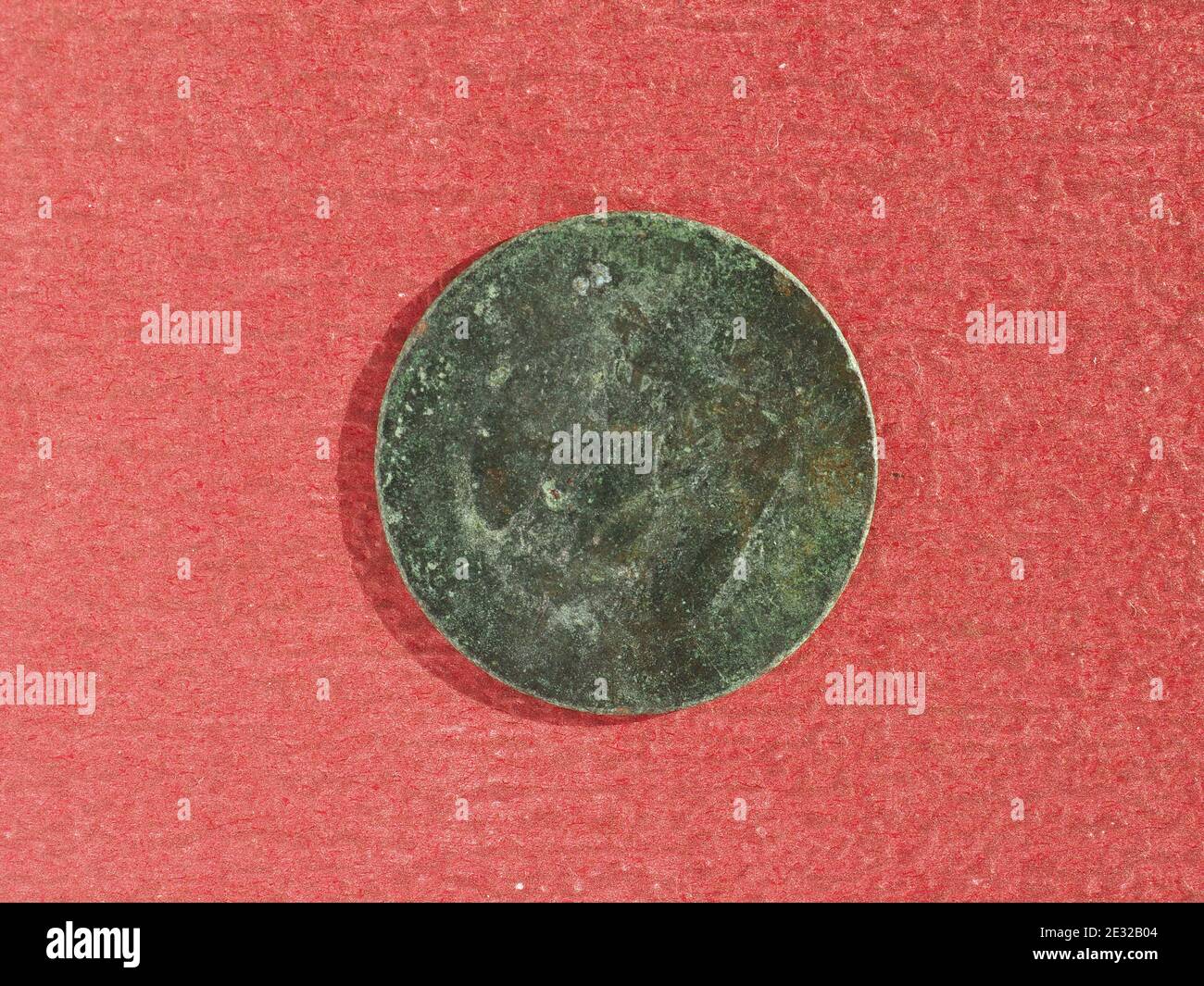 ancient unrecognisable rusted coin over red background Stock Photo - Alamy