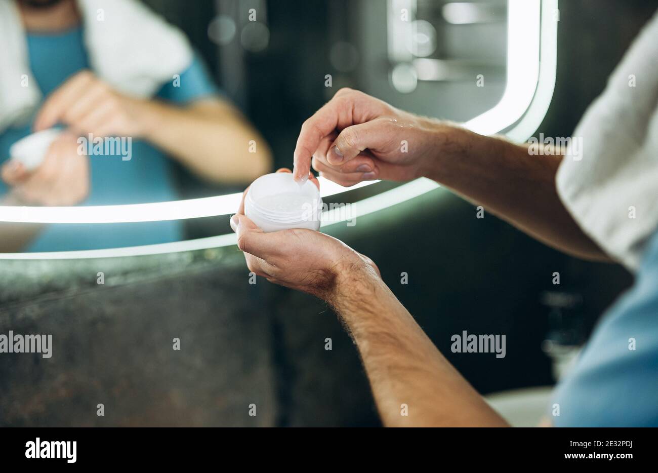 Close up photo man holding moisturising face cream in the bathroom ...