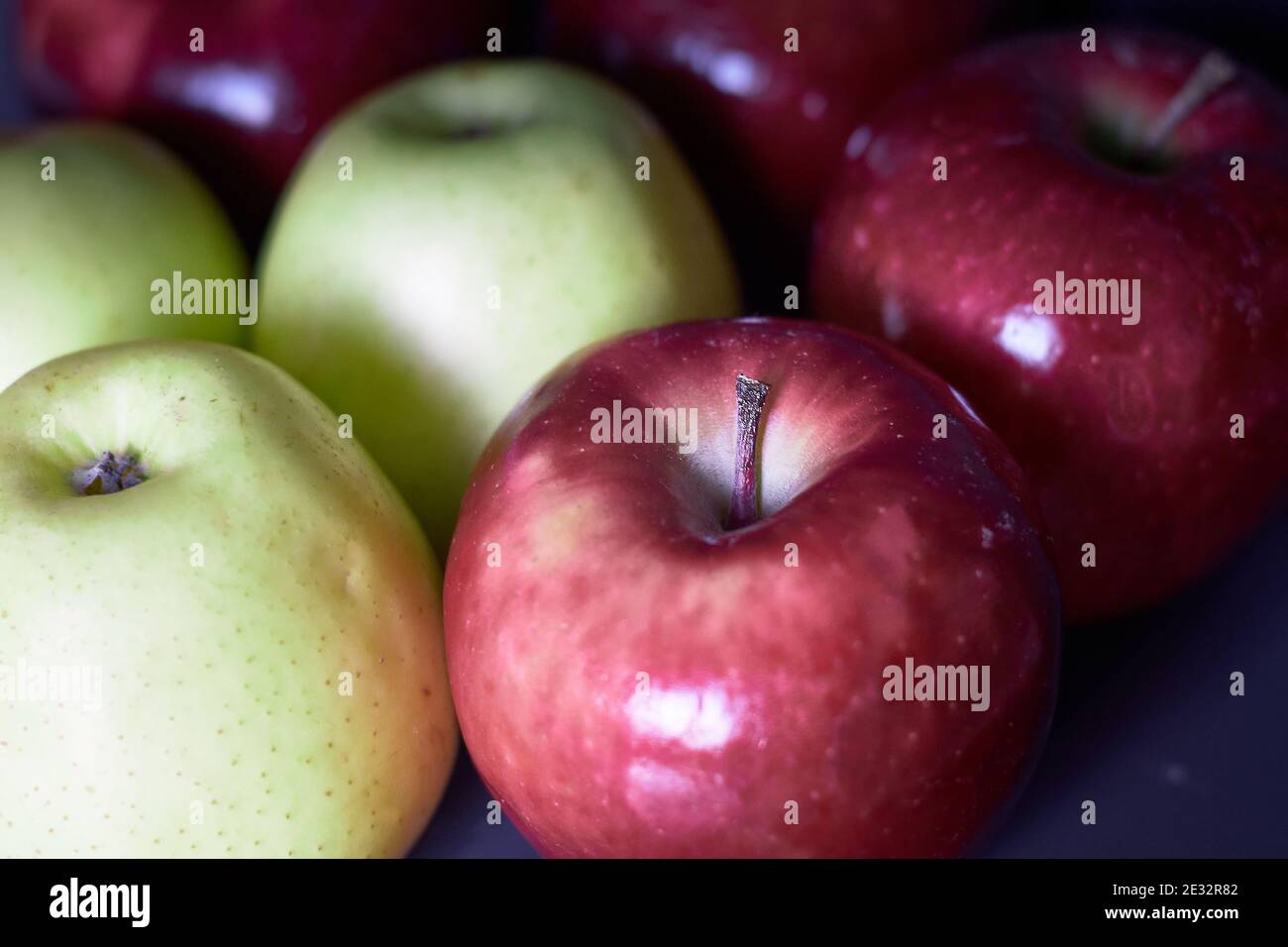Several bright red and green apples put in a row Stock Photo - Alamy