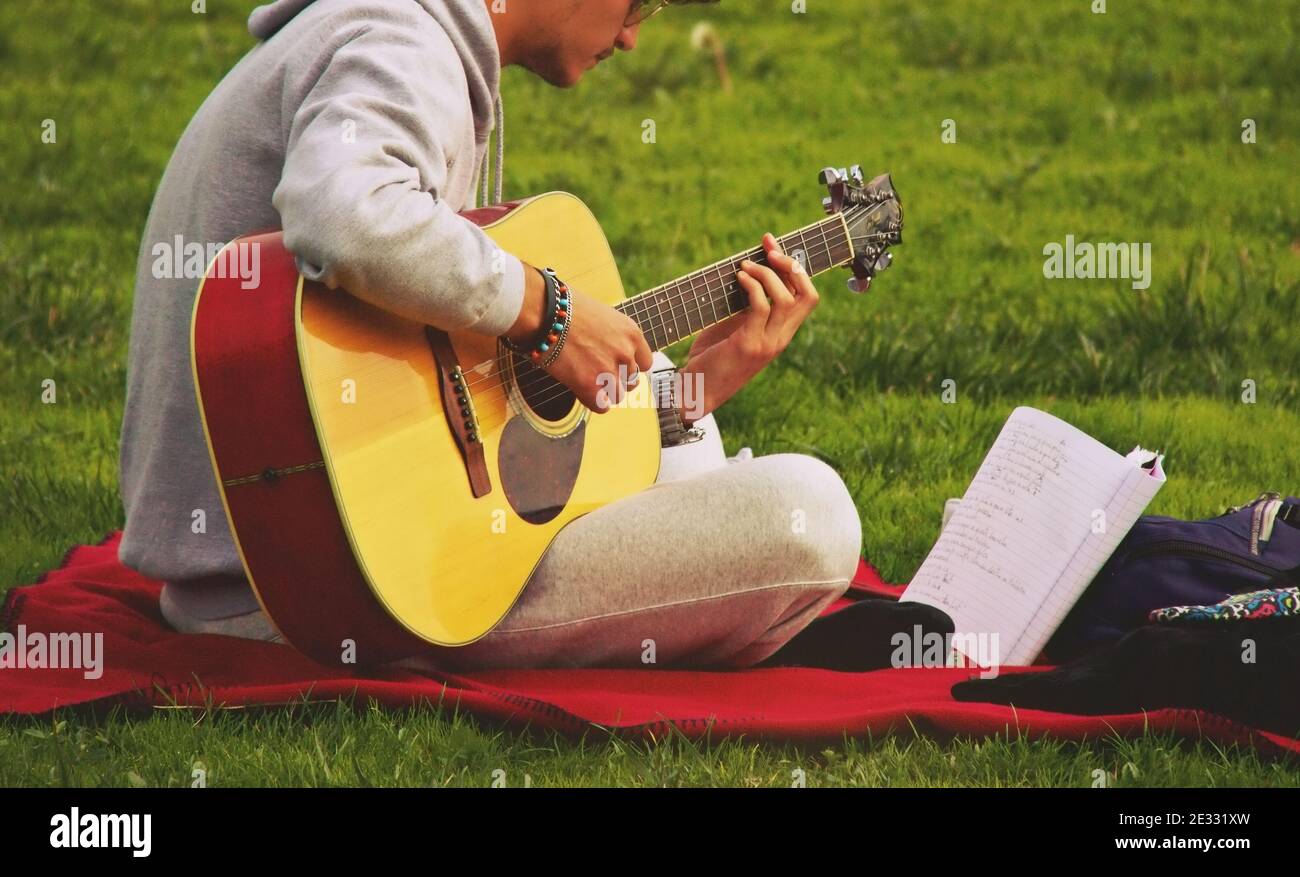 shot of a college student while studying guitar in a park Stock Photo ...