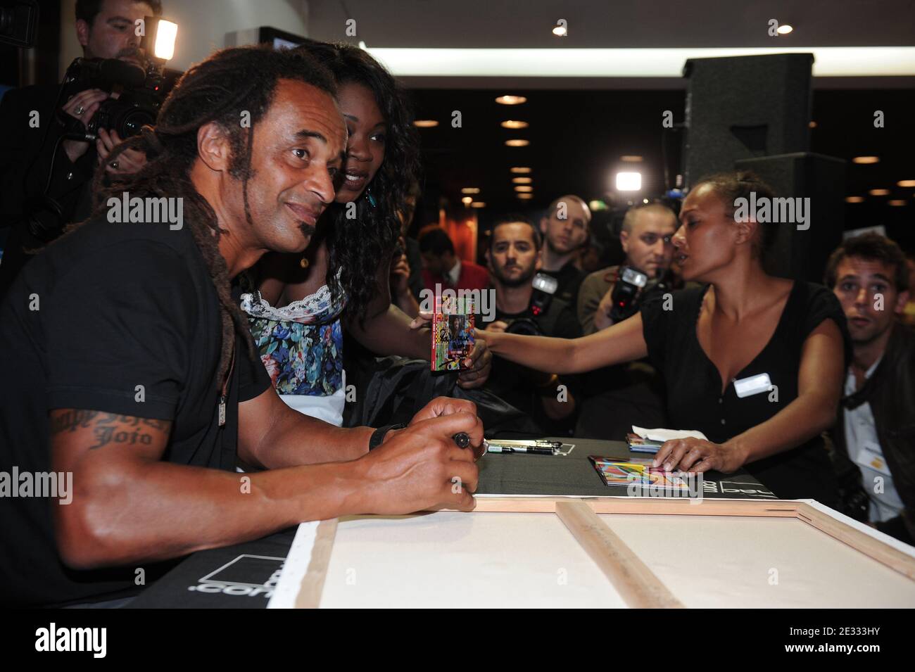 French singer Yannick Noah signs an autograph during a dedication ...