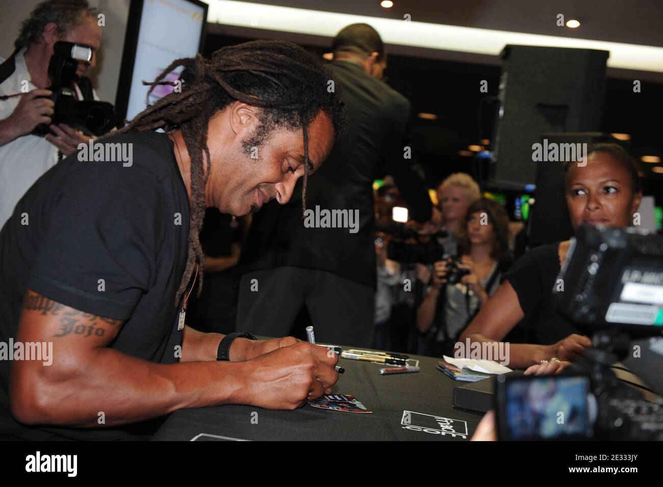 French singer Yannick Noah signs an autograph during a dedication ...