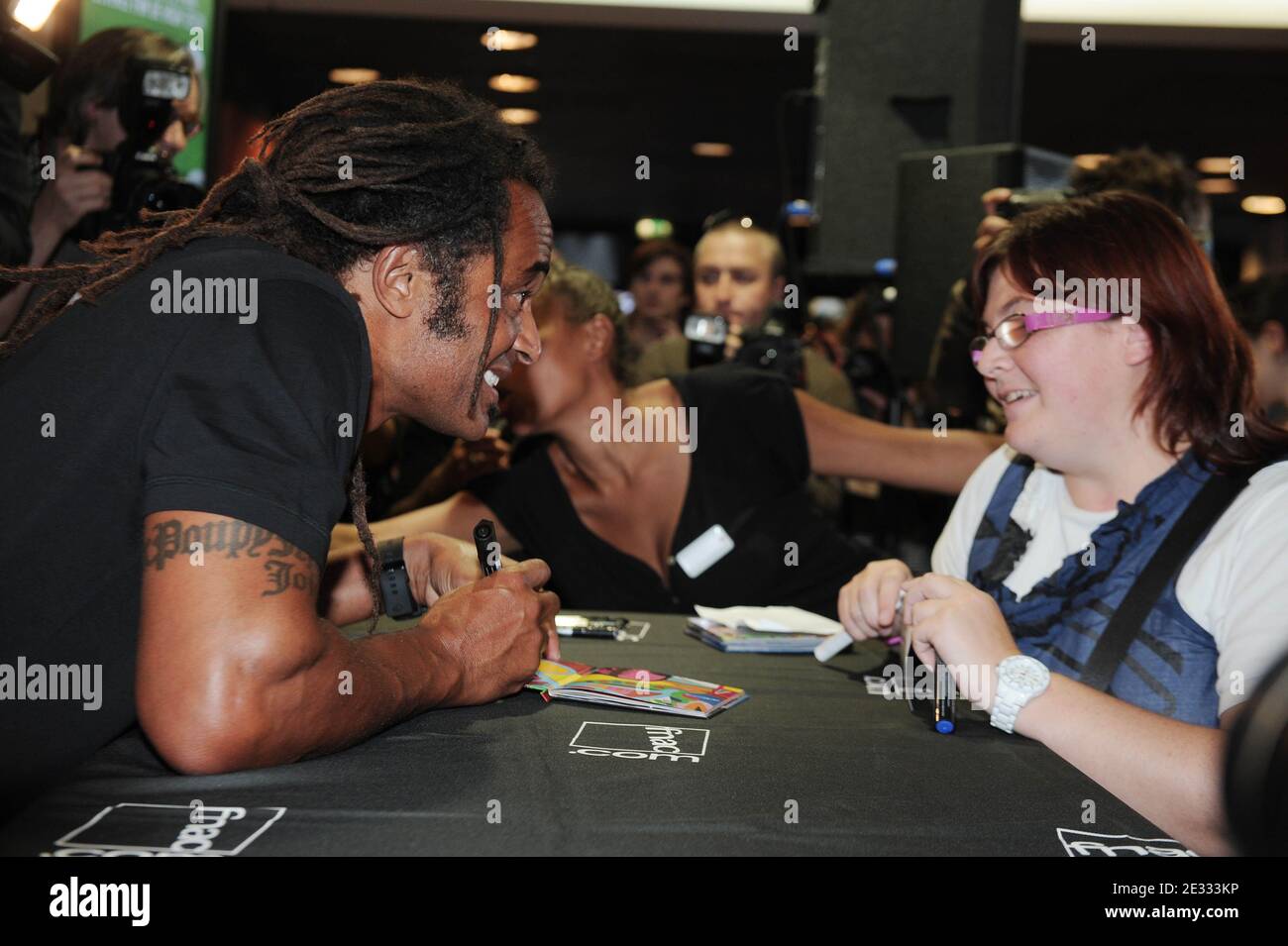 French singer Yannick Noah signs an autograph during a dedication ...