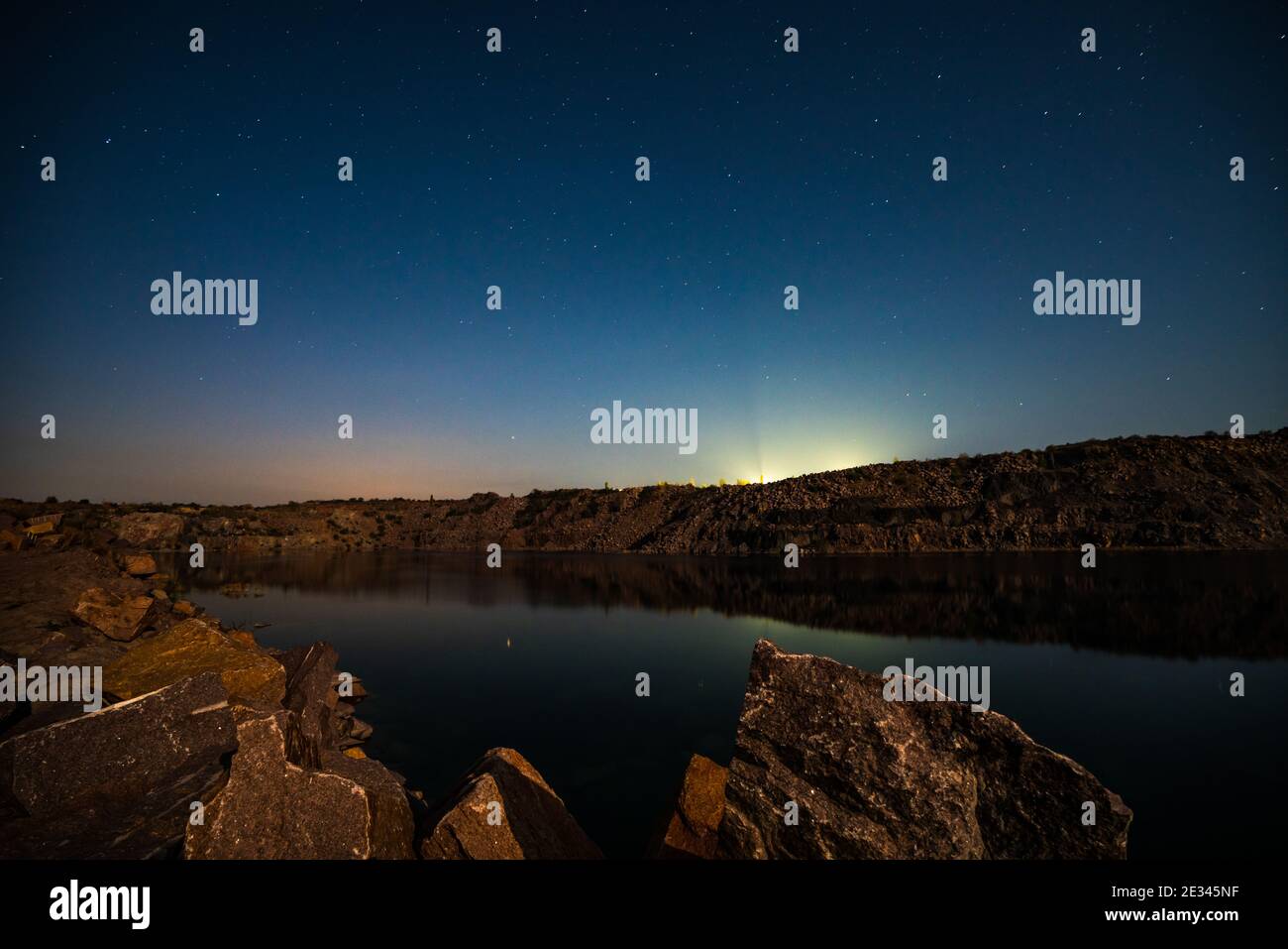Beautiful lake surrounded by large piles of stone waste from hard work ...