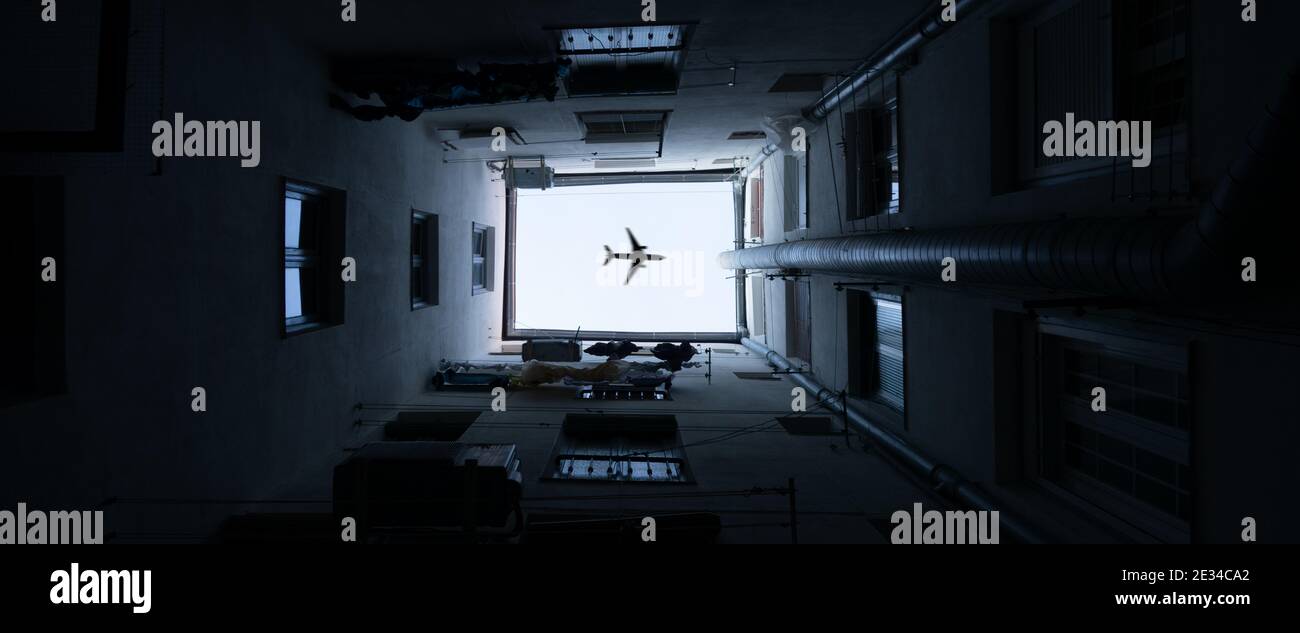 Top view shot of a flying plane over the buildings Stock Photo - Alamy