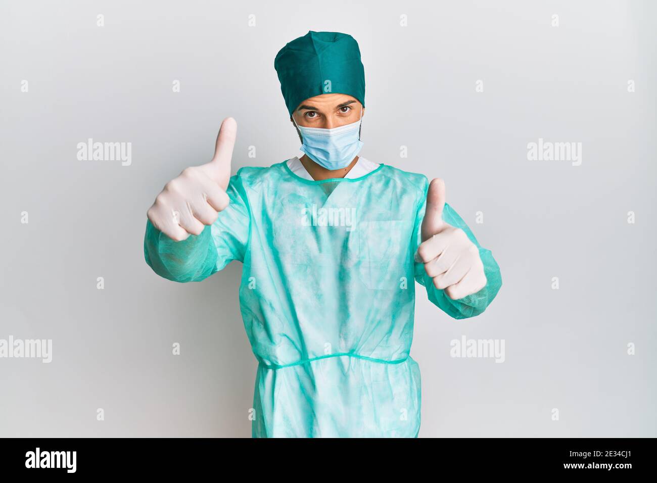 Young handsome man wearing surgeon uniform and medical mask approving ...