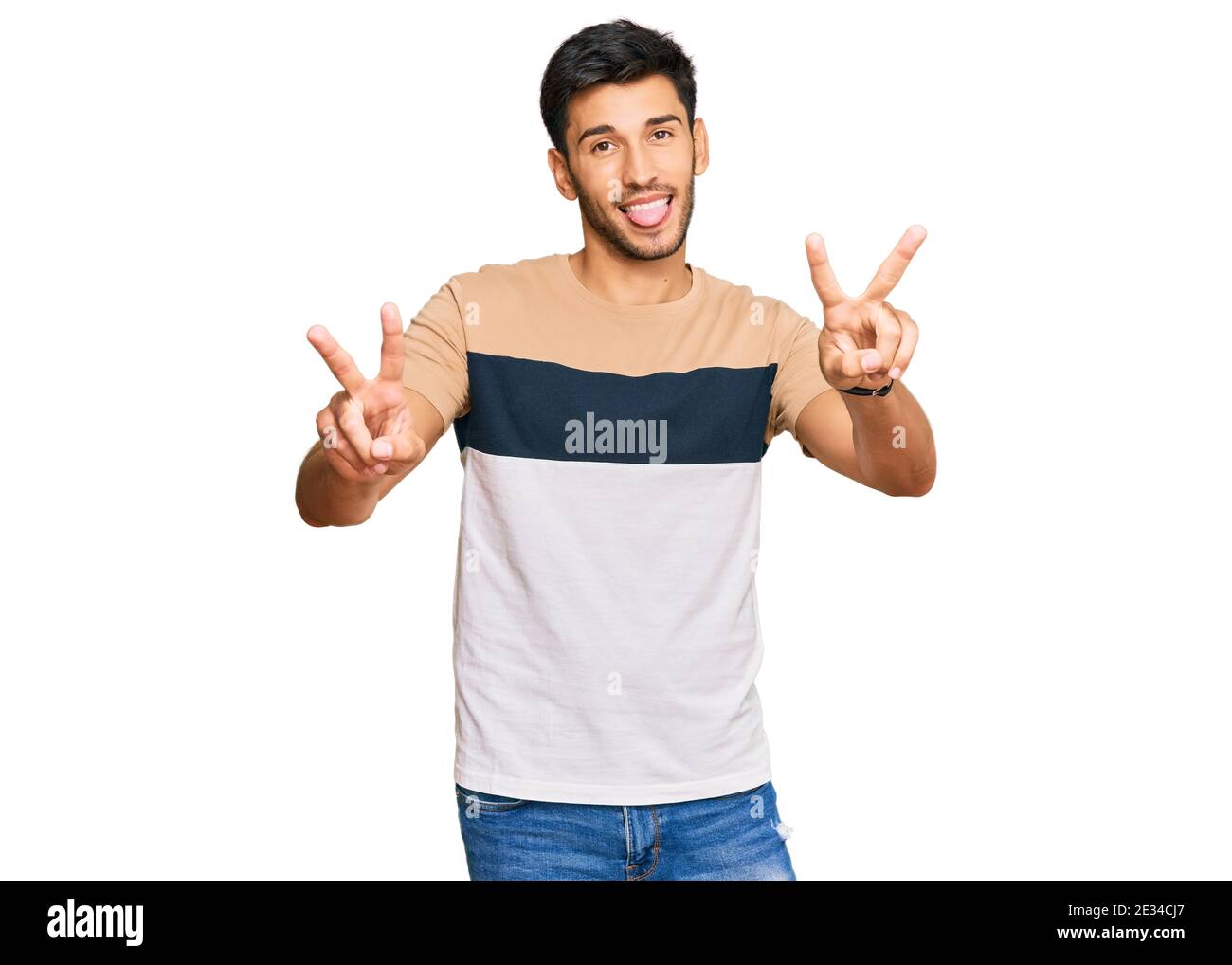 Young handsome man wearing casual clothes smiling with tongue out ...