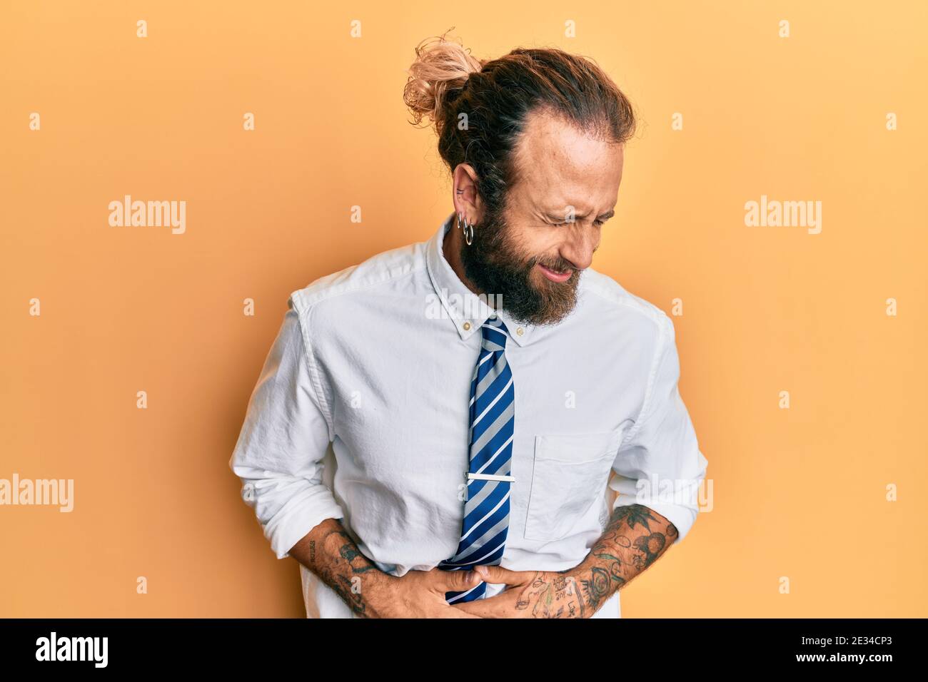 Handsome man with beard and long hair wearing business clothes with ...