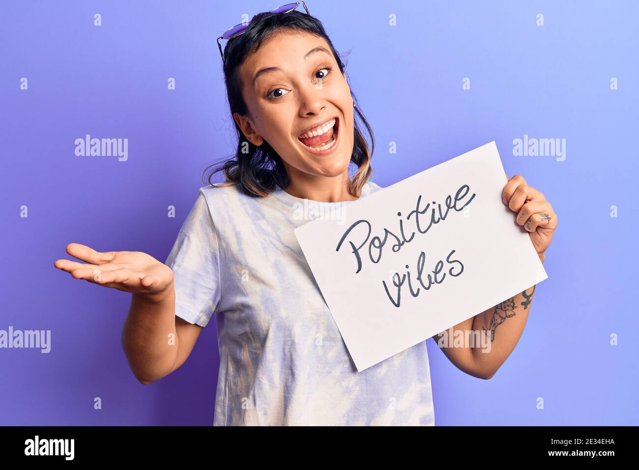Young woman holding positive vibes banner celebrating achievement with ...