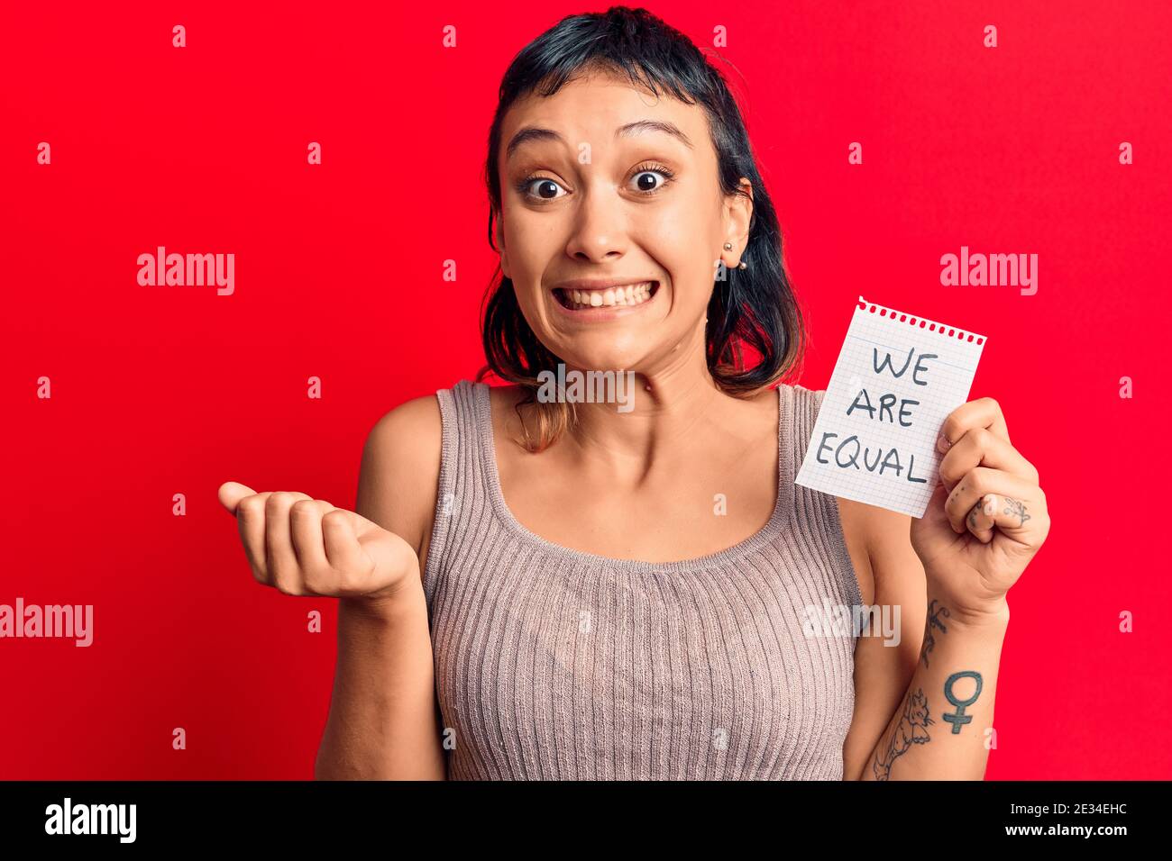 Young woman holding we are equal paper screaming proud, celebrating ...