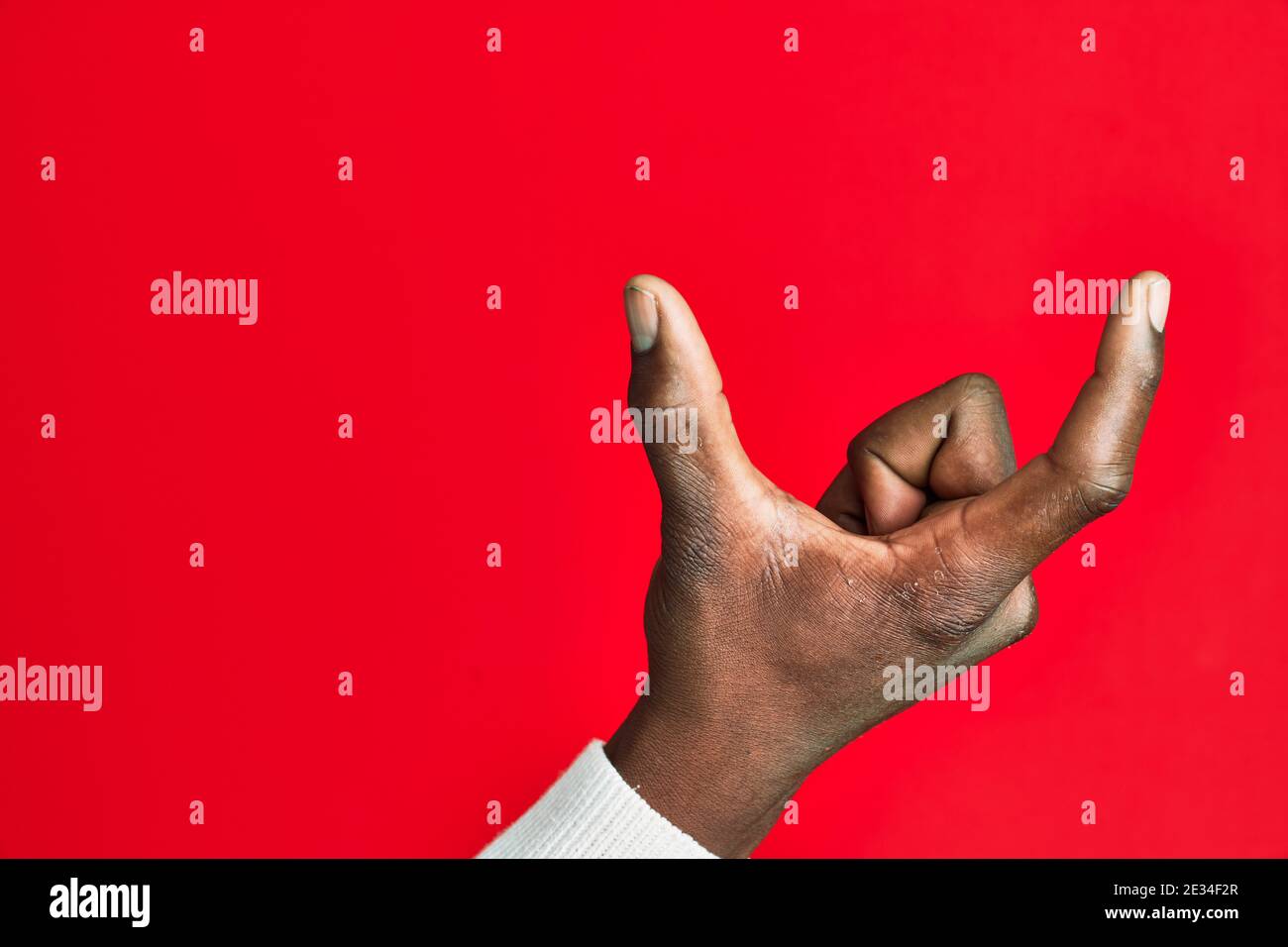Arm and hand of african american black young man over red isolated ...