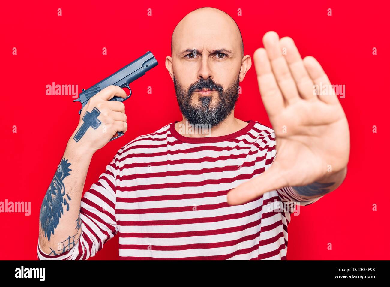 Young handsome man holding gun with open hand doing stop sign with ...