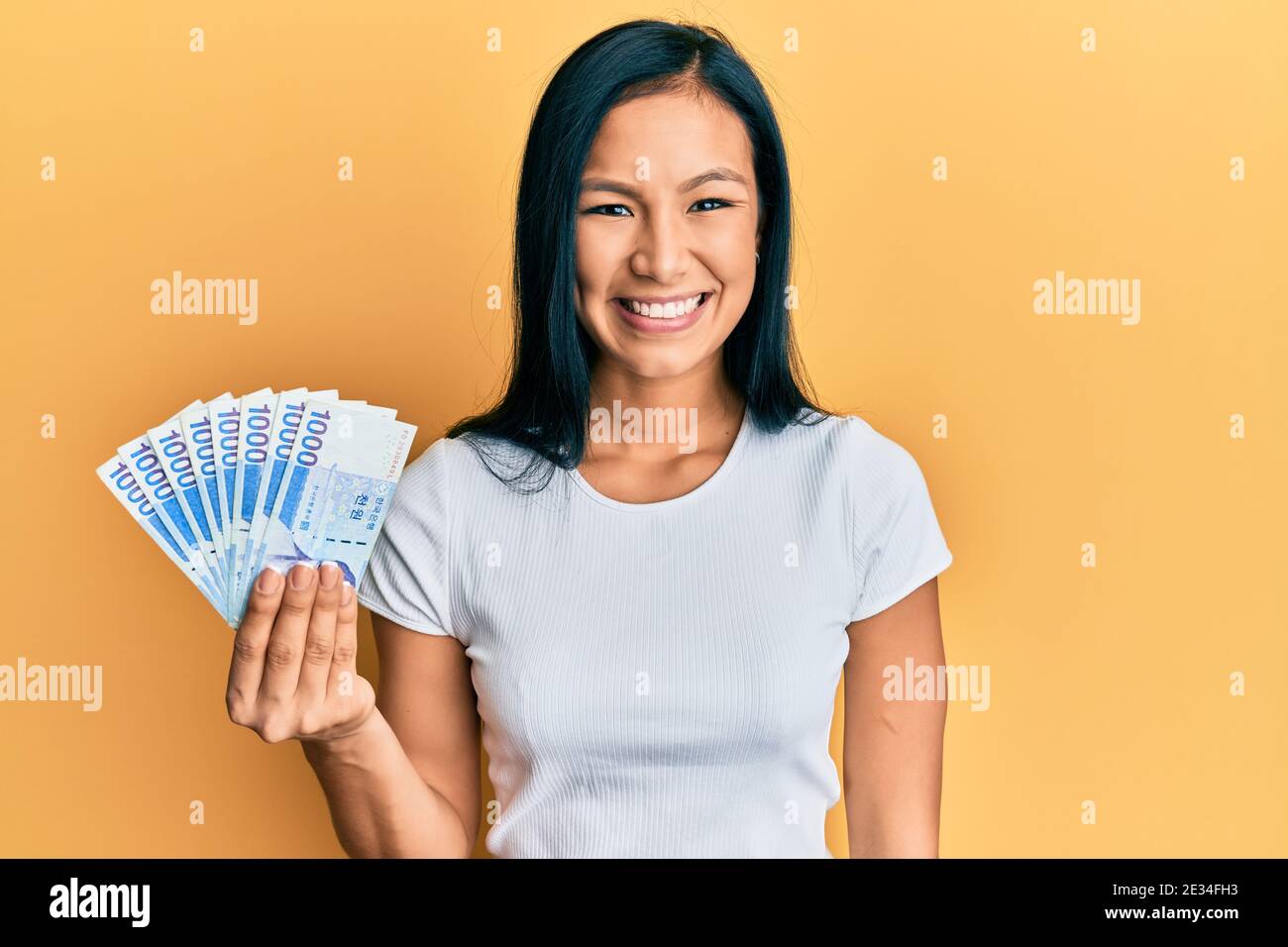 Beautiful hispanic woman holding 1000 south korean won banknotes ...