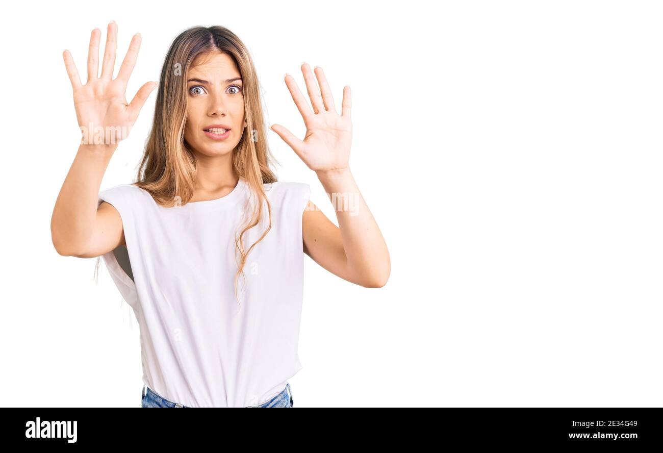 Beautiful caucasian woman with blonde hair wearing casual white tshirt ...