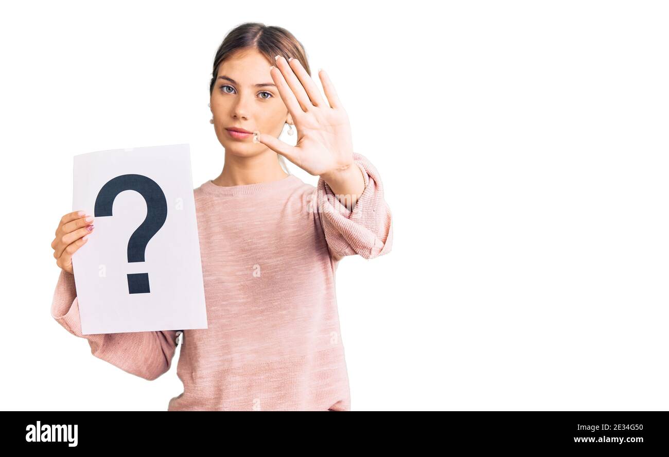 Beautiful caucasian woman with blonde hair holding question mark with ...