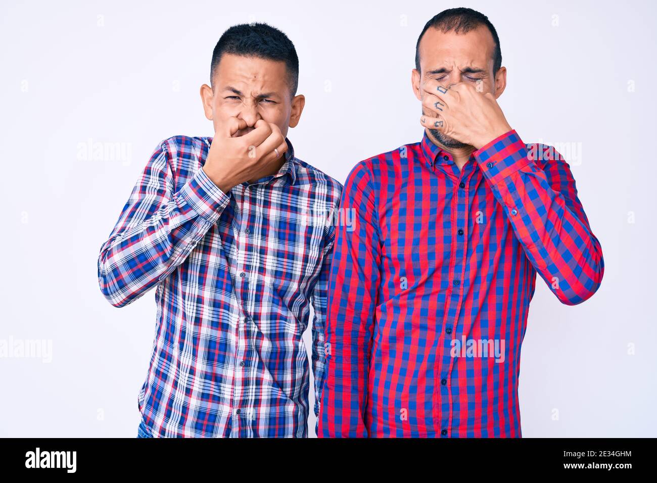 Young gay couple of two men wearing casual clothes smelling something ...