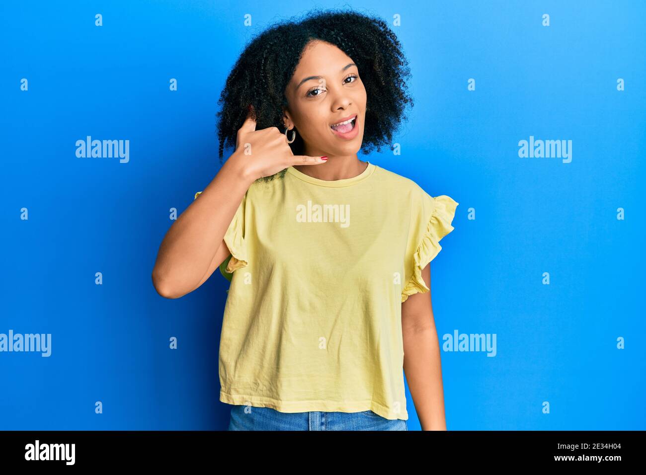 Young african american girl wearing casual clothes smiling doing phone ...