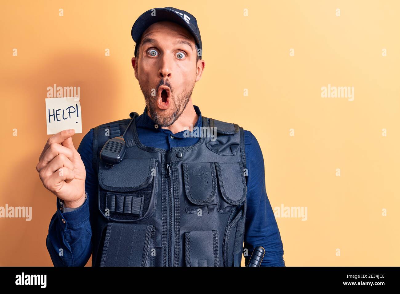 Handsome policeman wearing uniform and bulletprof holding reminder with ...
