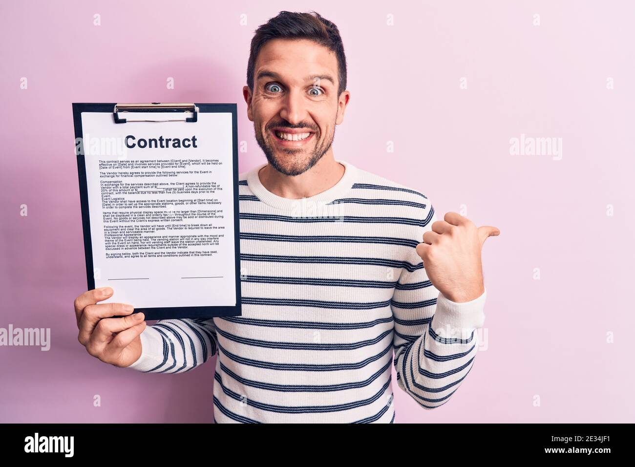 Young handsome man holding clipboard with contract document paper over ...