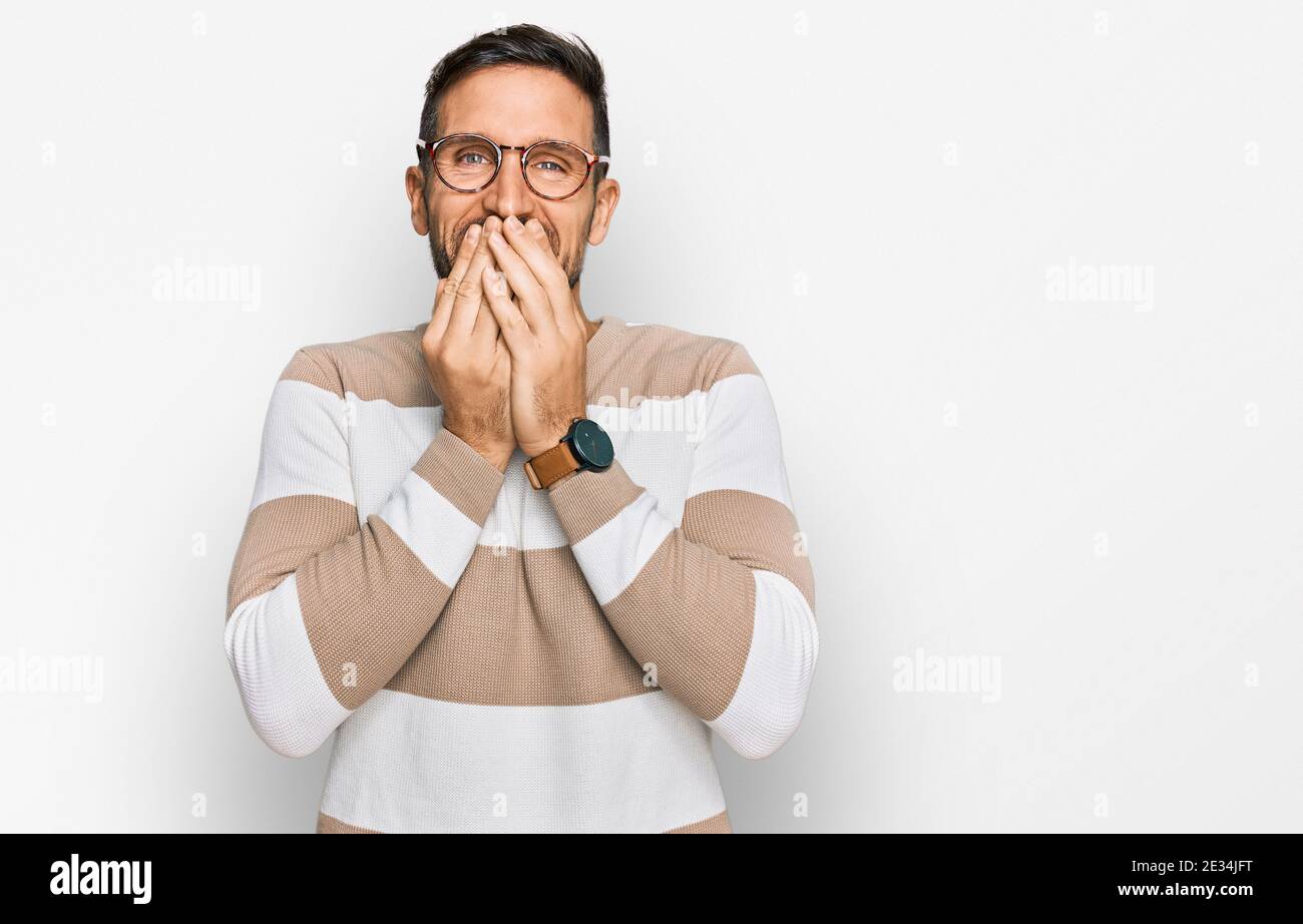 Handsome man with beard wearing casual clothes and glasses laughing and ...
