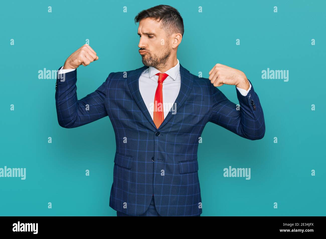 Handsome man with beard wearing business suit and tie showing arms ...