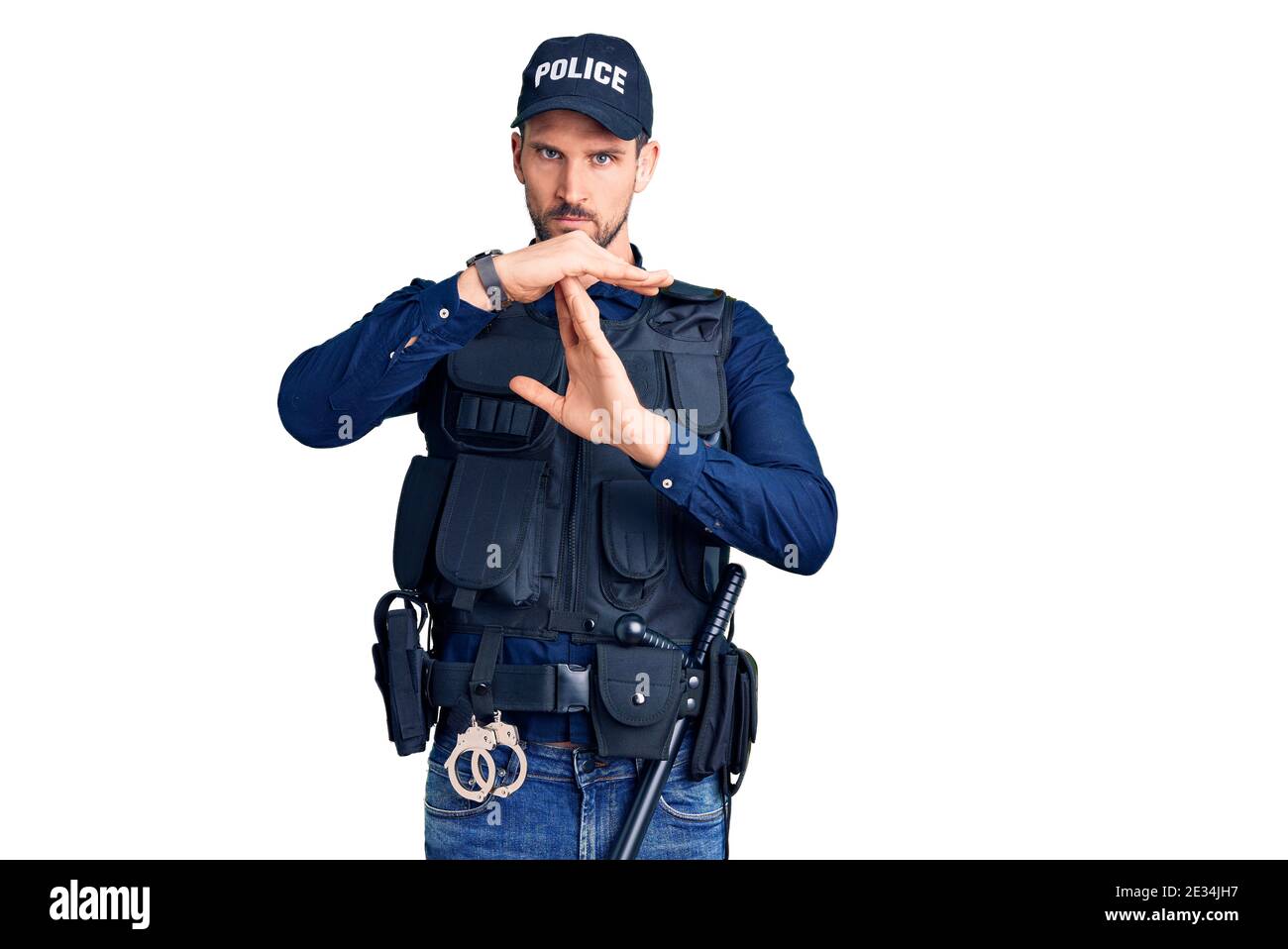 Young handsome man wearing police uniform doing time out gesture with ...