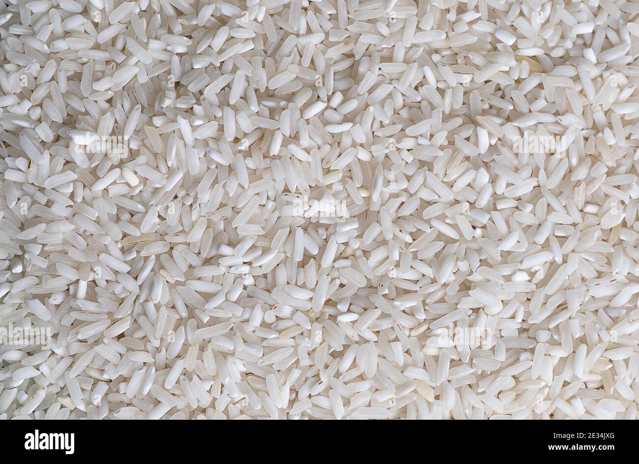 Raw white long rice macro background Stock Photo - Alamy