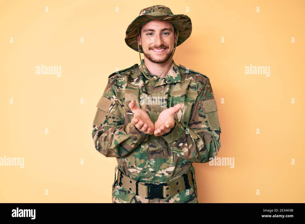 Young caucasian man wearing camouflage army uniform smiling with hands ...