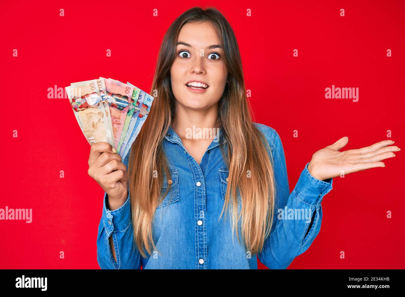 Beautiful caucasian woman holding canadian dollars celebrating ...