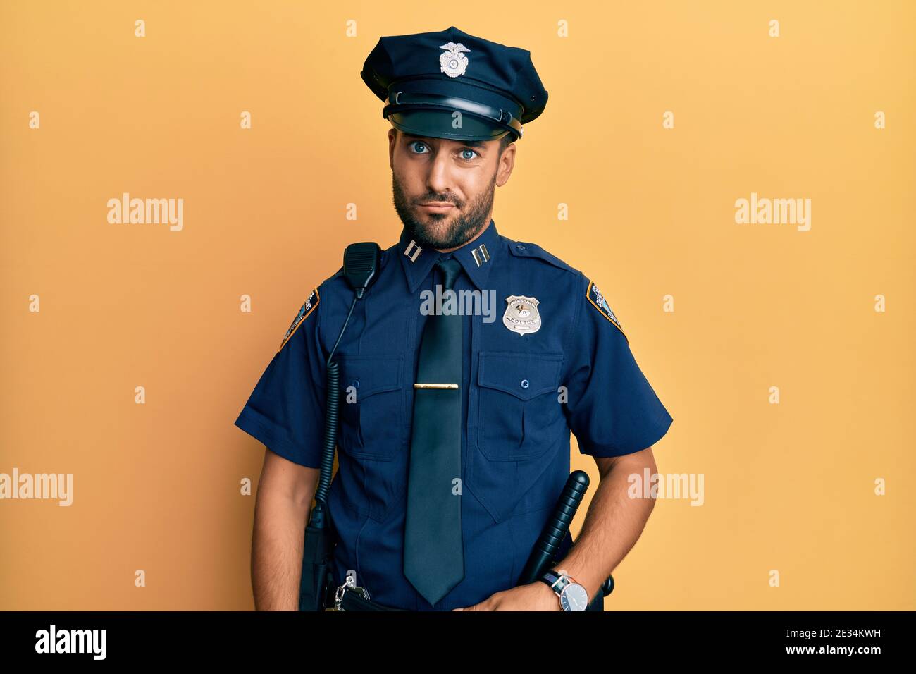Handsome hispanic man wearing police uniform skeptic and nervous ...