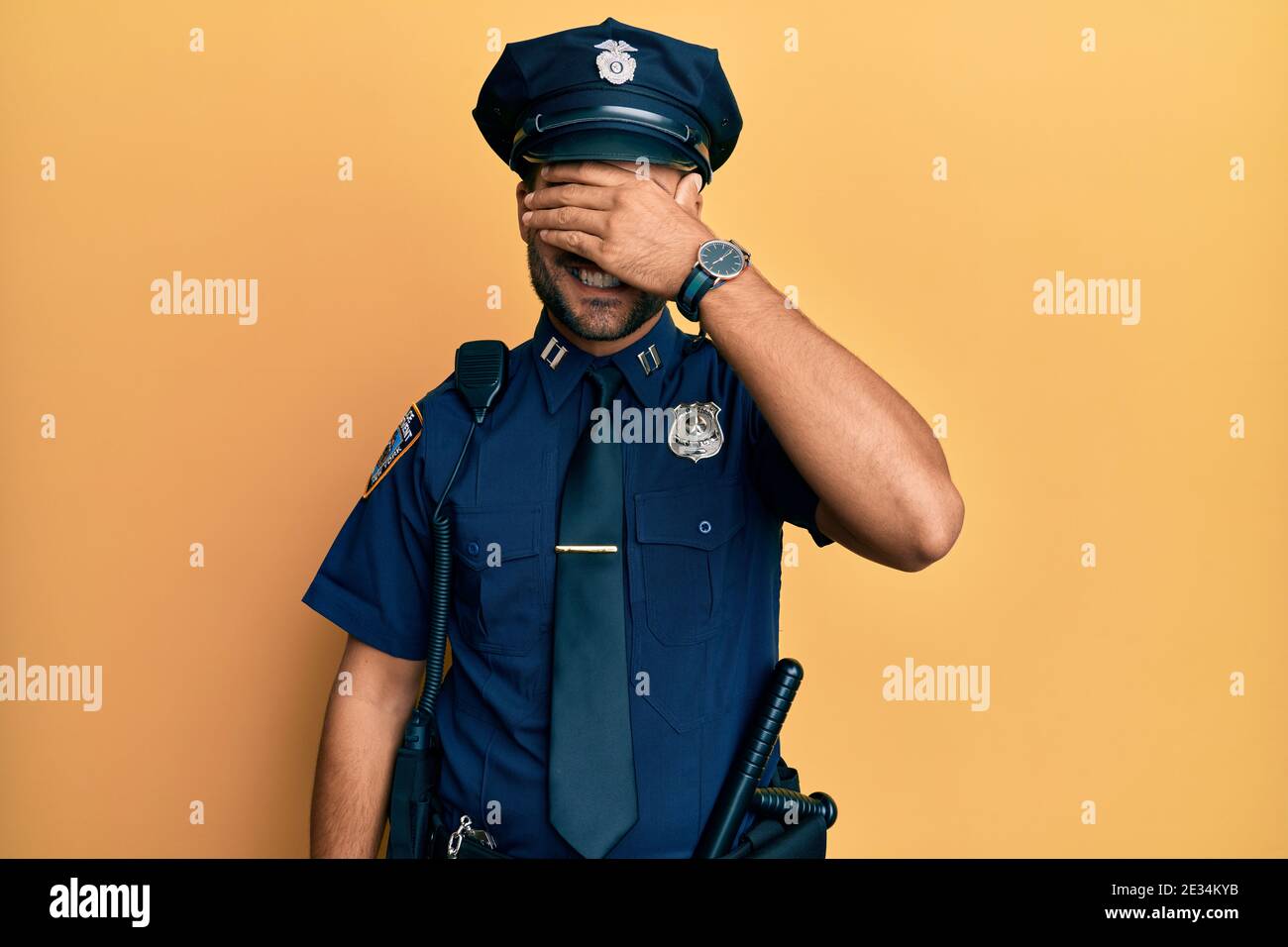 Handsome hispanic man wearing police uniform smiling and laughing with ...