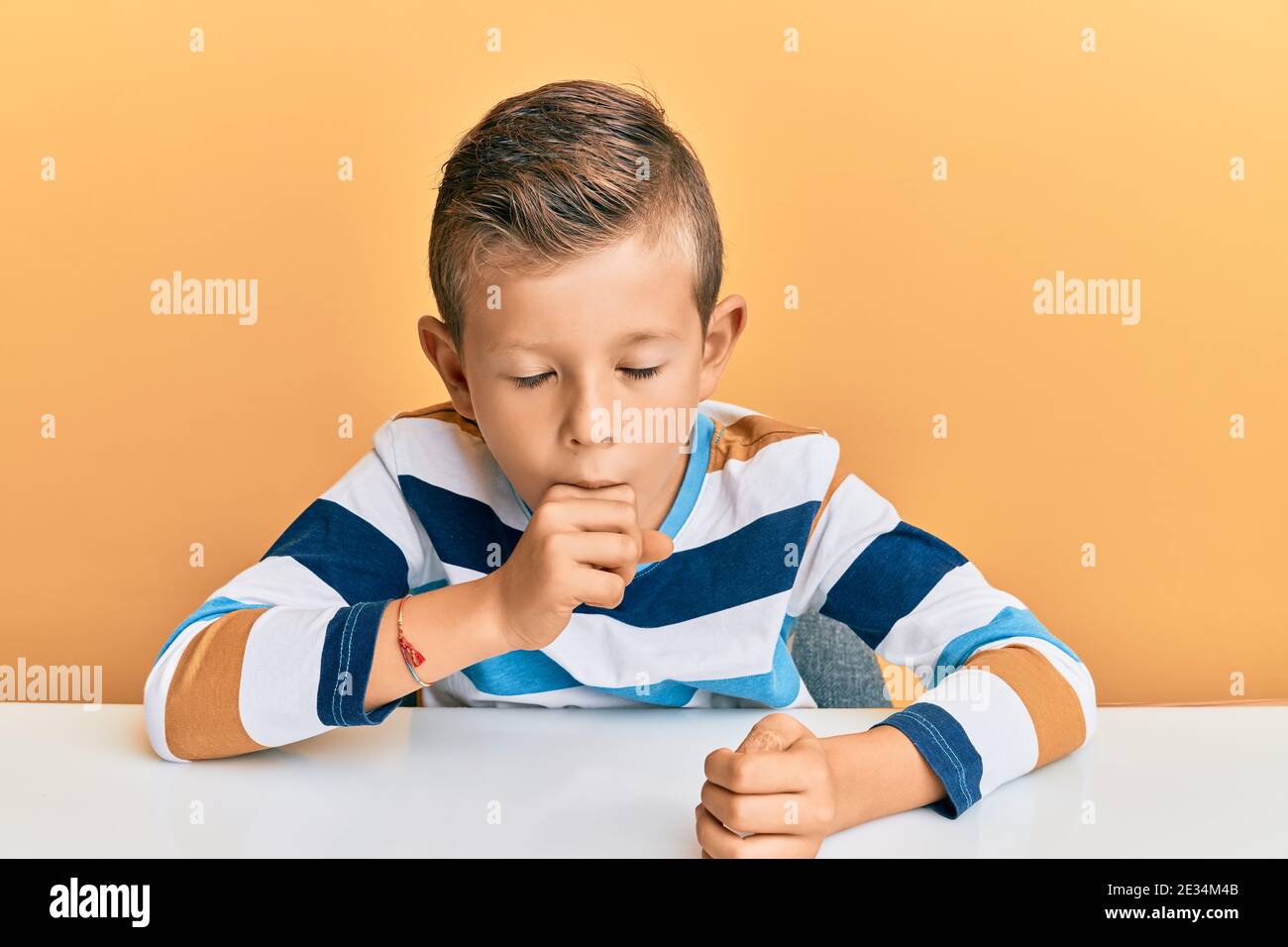 Adorable caucasian kid wearing casual clothes sitting on the table ...