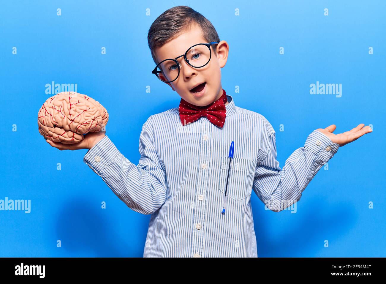 Cute blond kid wearing nerd bow tie and glasses holding brain ...