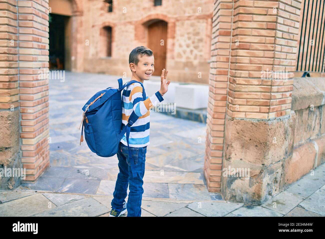 Adorable caucasian student boy smiling happy saying goodbye with hand ...