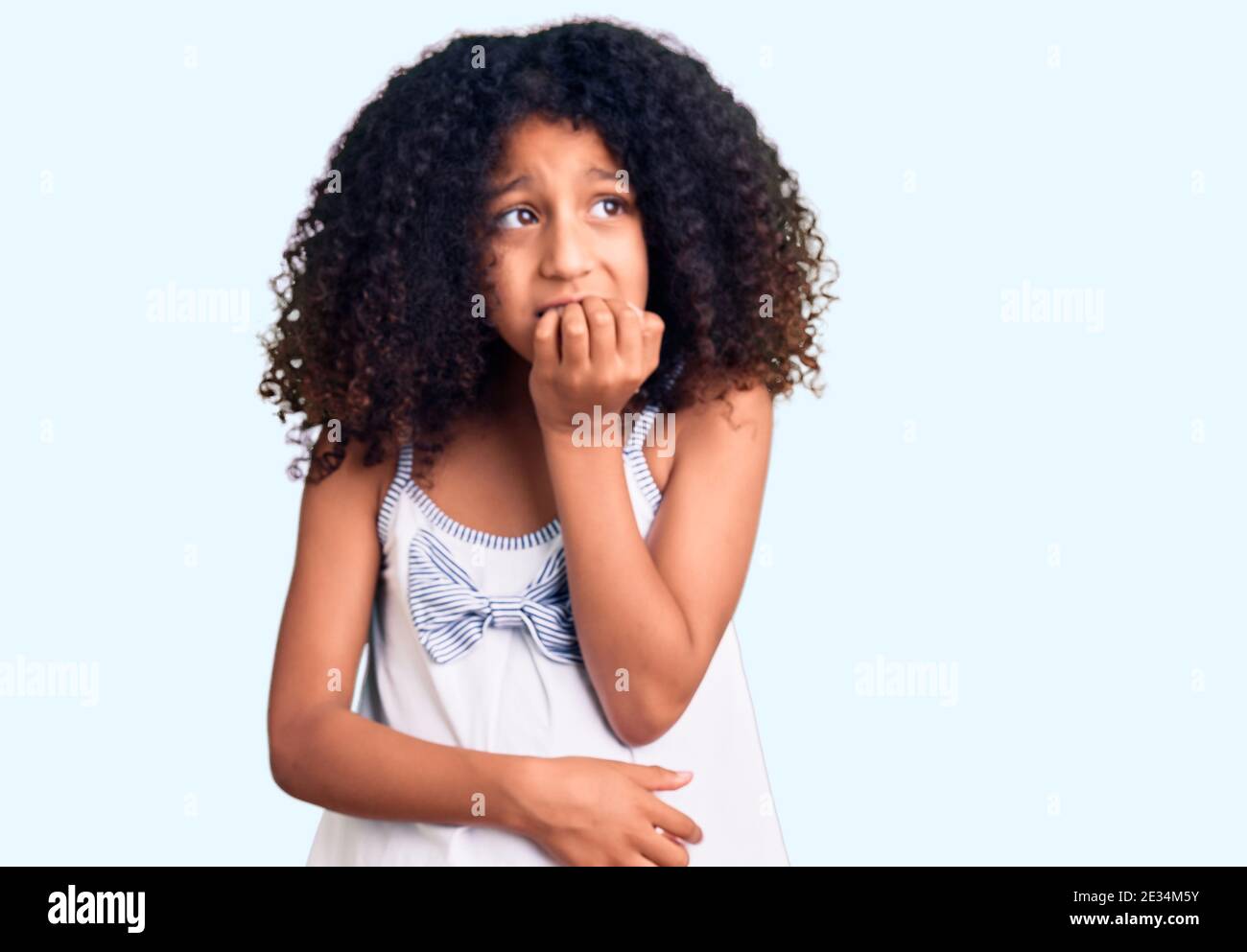 African american child with curly hair wearing casual clothes looking ...