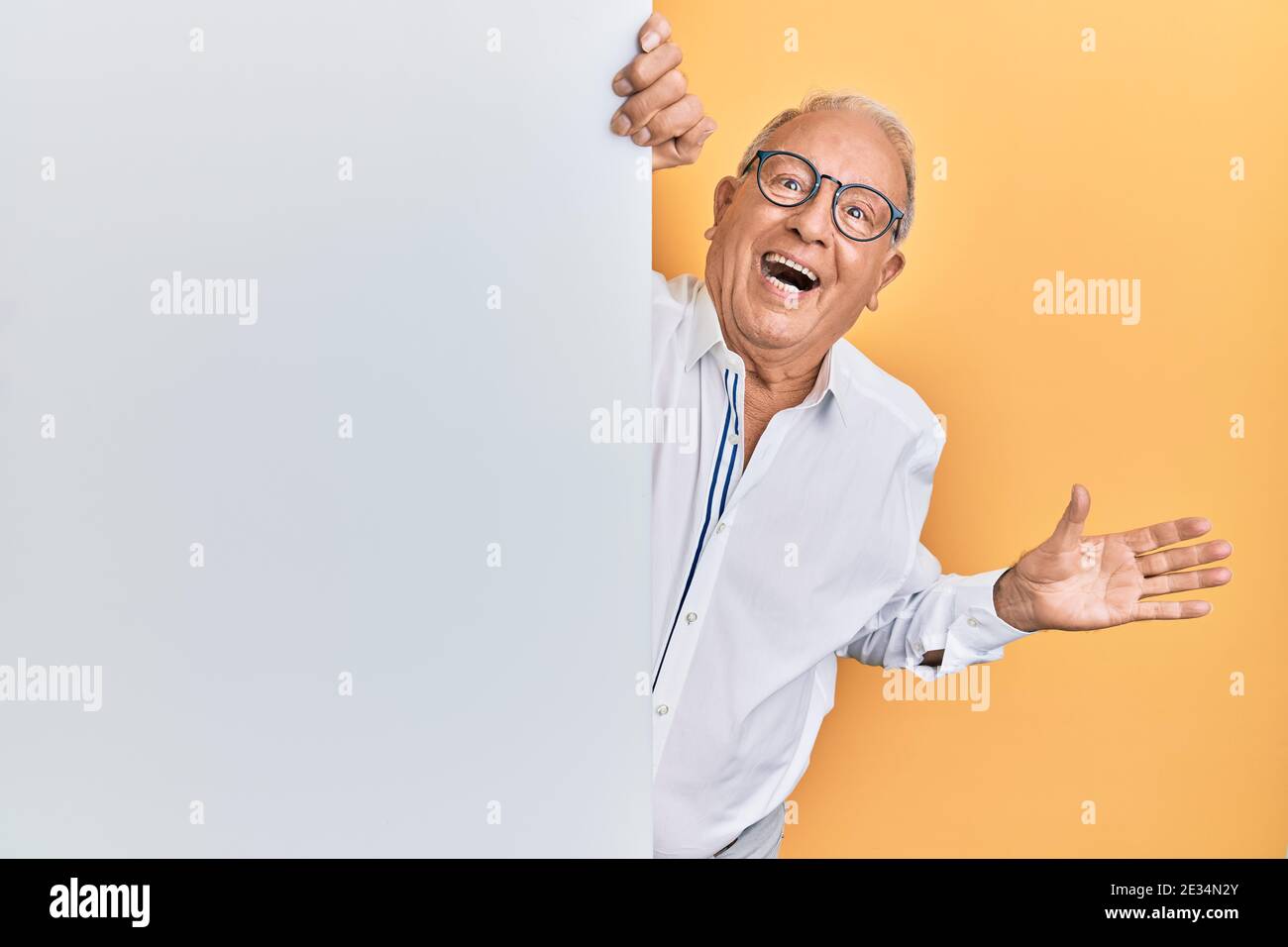 Senior caucasian man holding blank empty banner celebrating victory ...