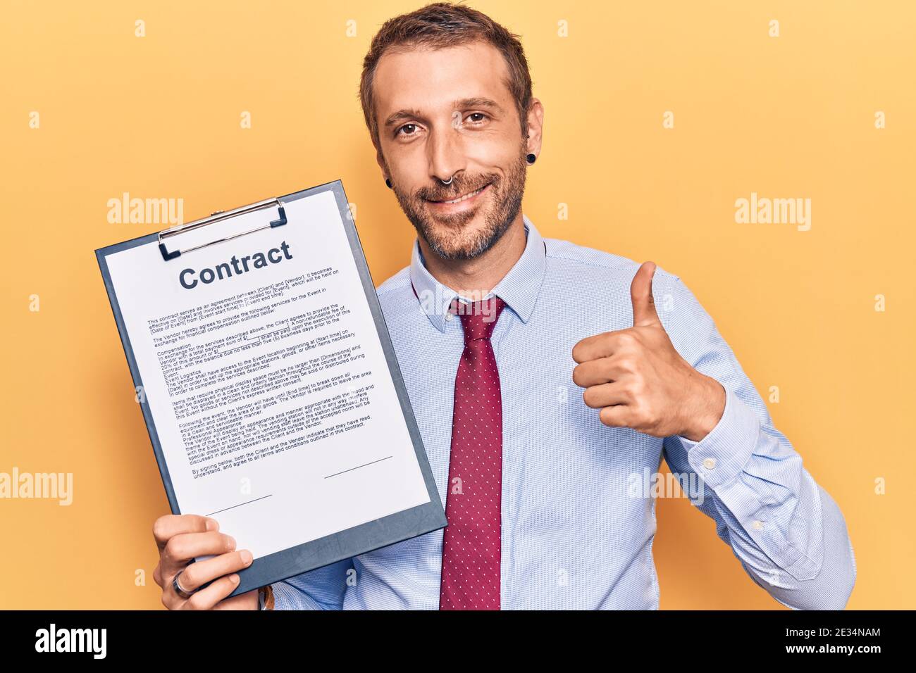 Young handsome man holding clipboard with contract document smiling ...