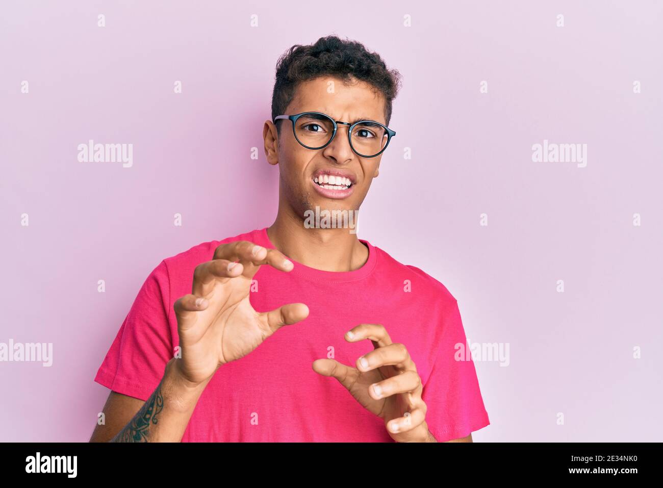 Young handsome african american man wearing glasses over pink ...