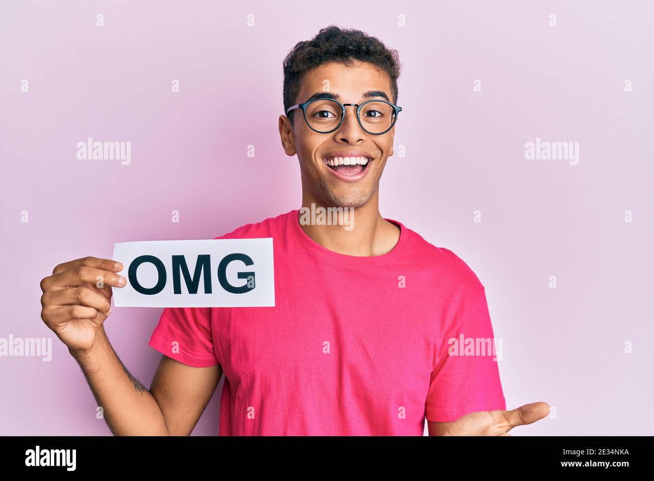 Young handsome african american man holding omg message paper ...