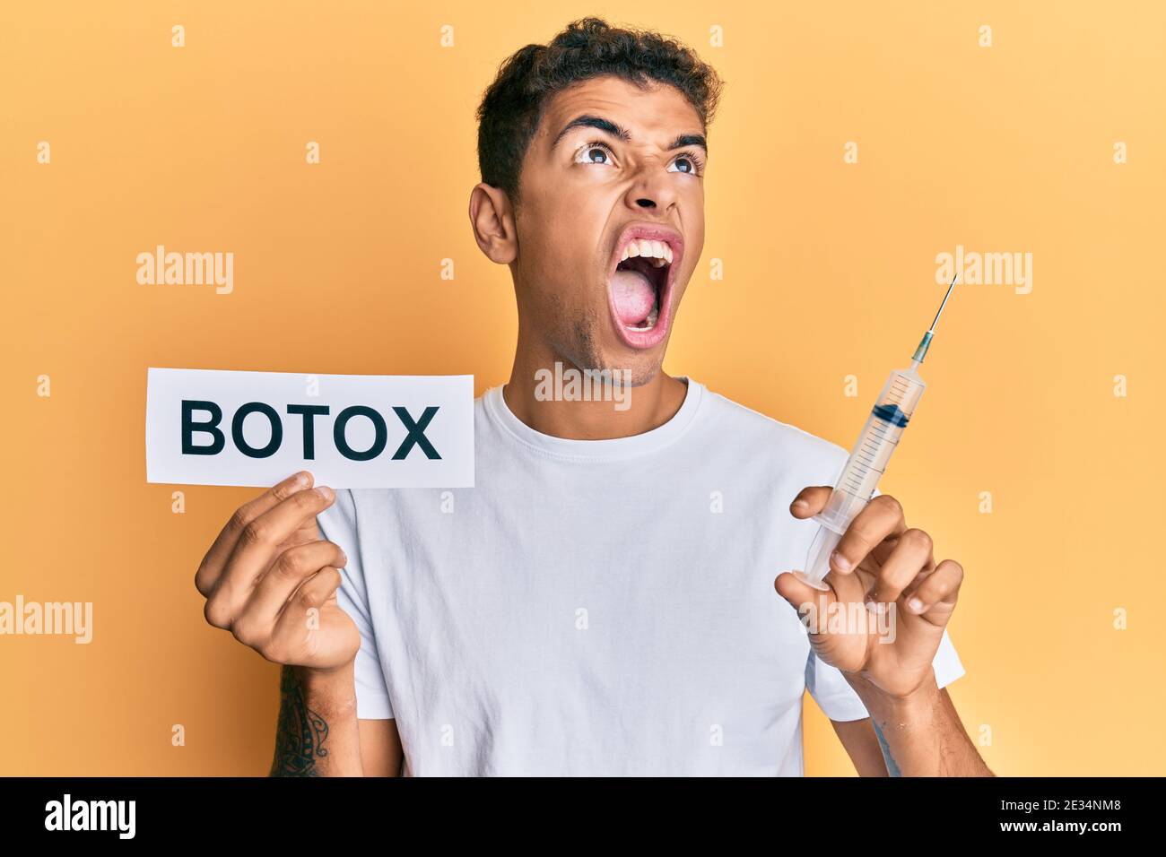 Young handsome african american man holding botox banner and needle ...