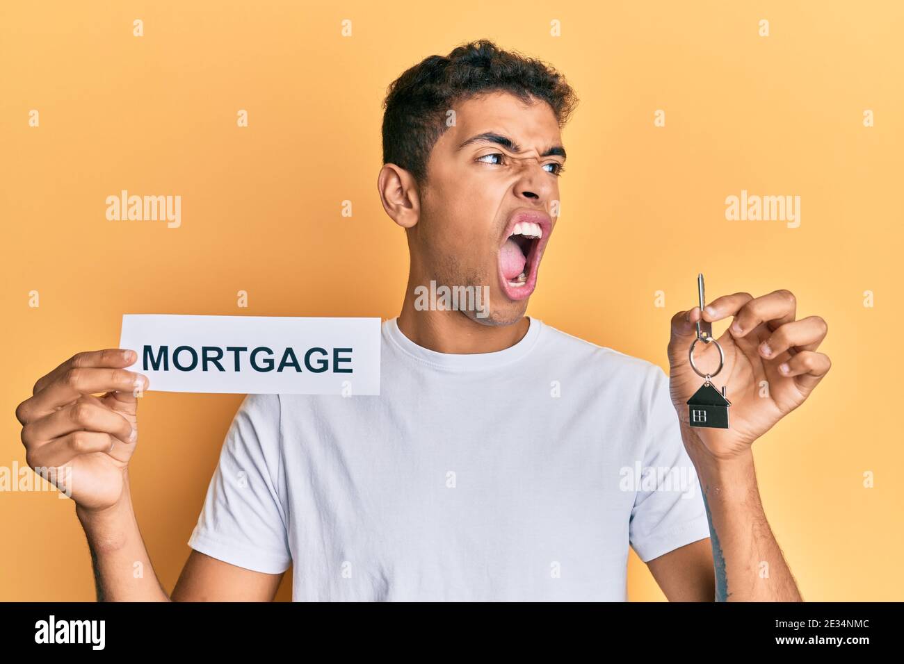 Young handsome african american man holding paper with mortgage word ...